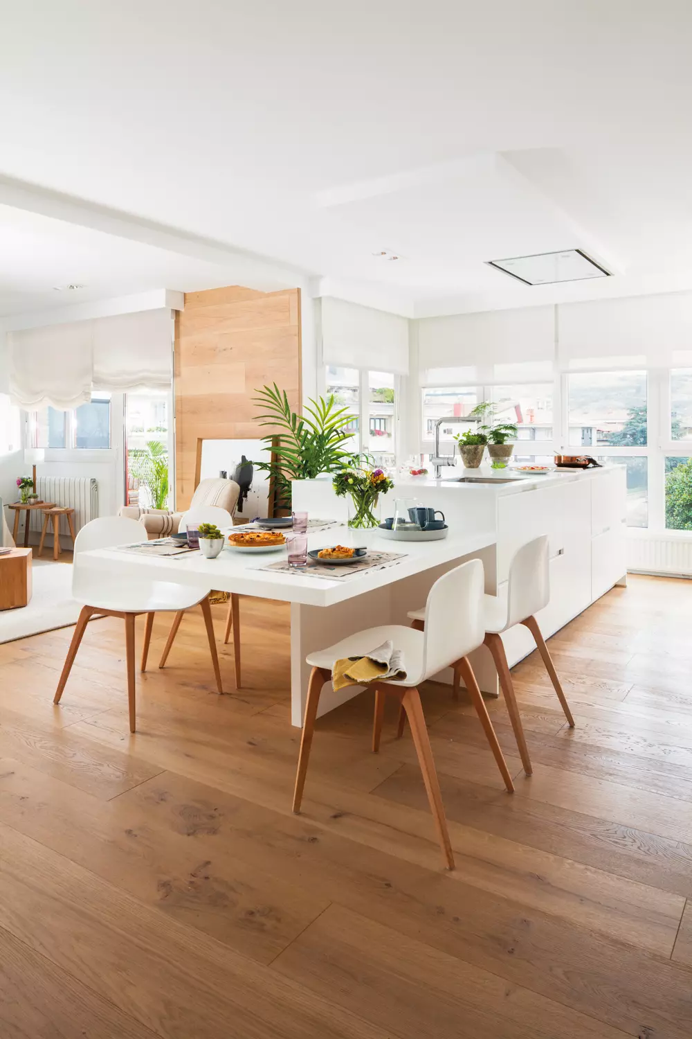 White kitchen with island and attached wooden table