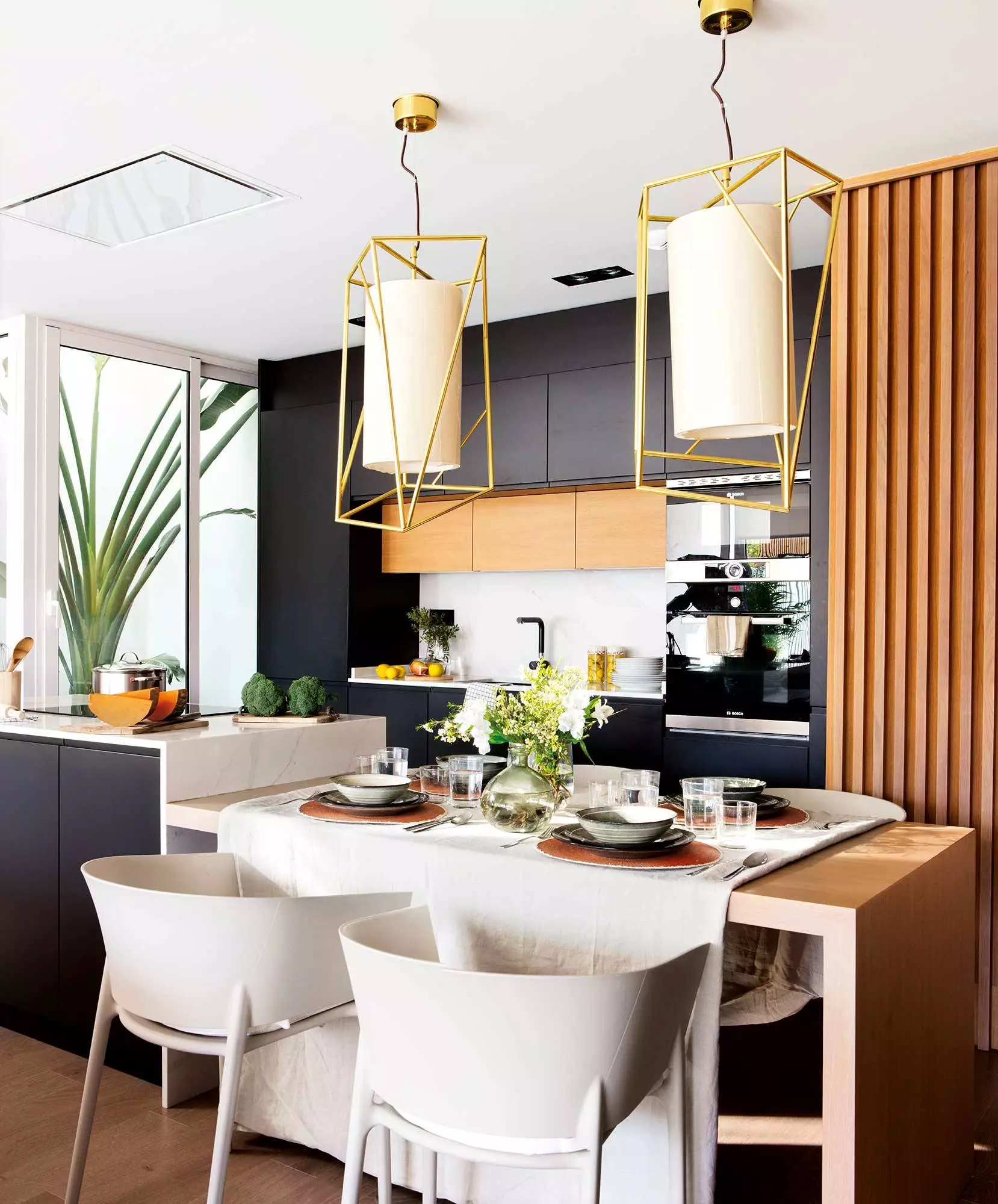 Kitchen with anthracite gray furniture and wooden table attached to island 00519920