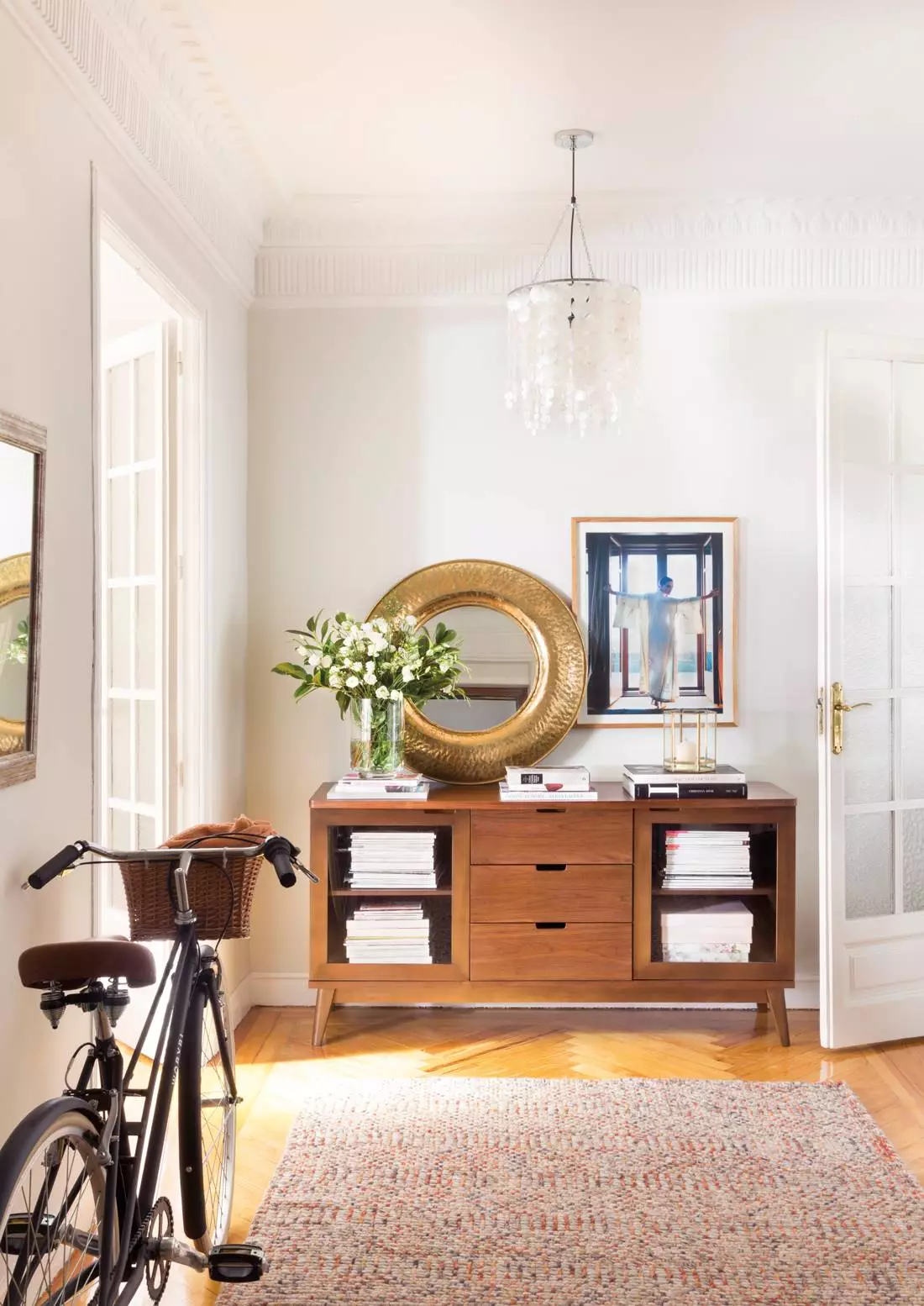 Hallway with midcentury dresser rug and round gilt mirror_457273