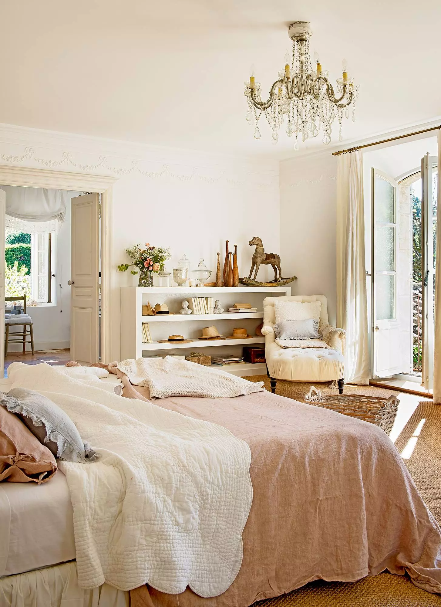 Classic bedroom with tufted armchair and low white bookcase 00386114