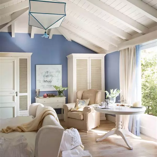 Blue bedroom with table and armchair