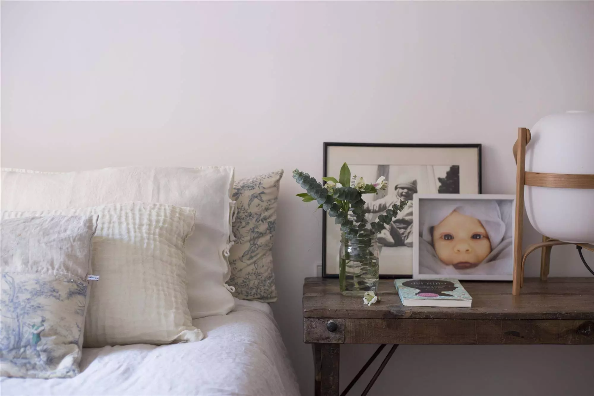 Slaapkamer met een oude tafel geplaatst als bijzettafel.