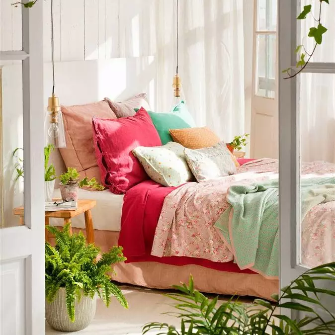 Schlafzimmer mit Bett mit rosa und grünen Textilien mit Blumenmustern