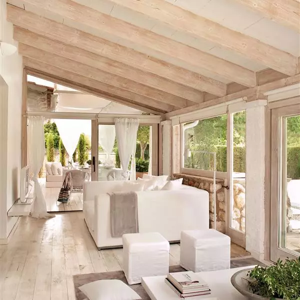 Current living room in white with large windows to the garden, wooden floor and stripped beams