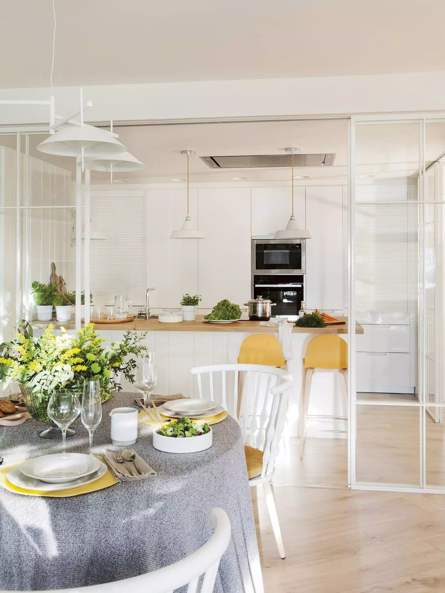 Cuisine blanche séparée du bureau par une verrière