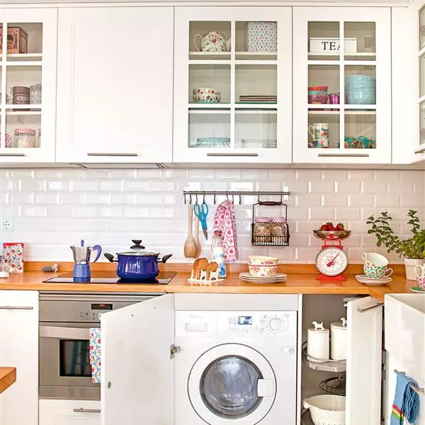 White kitchen with wooden countertop and hidden washing machine behind cabinet