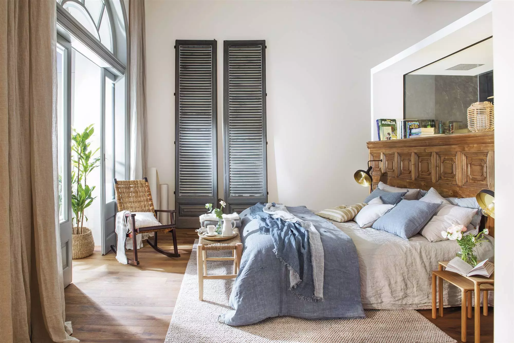 White bedroom with wooden headboard and shutters against the wall_00511532