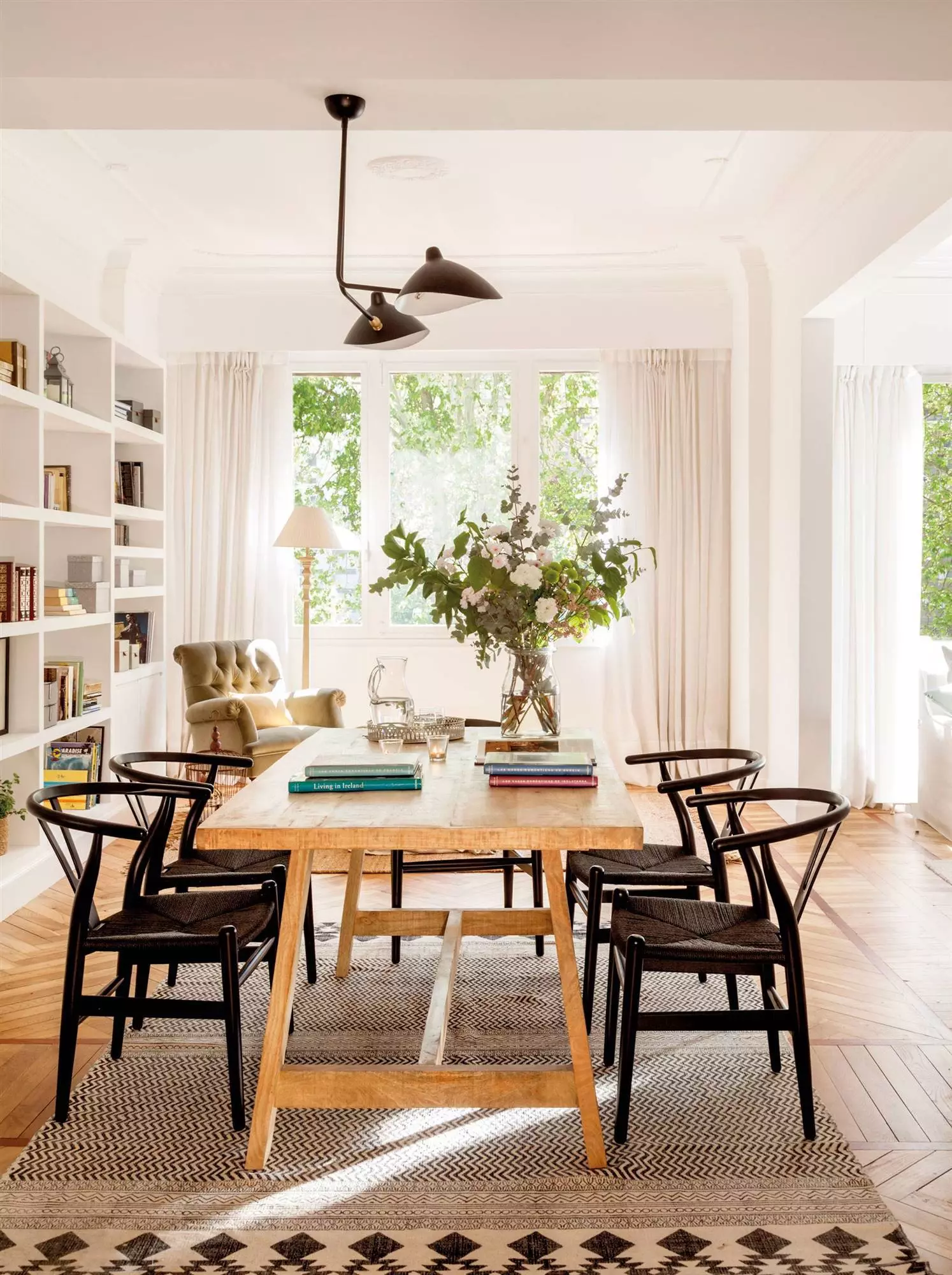 Sala de jantar contemporânea com mesa de madeira e cadeiras pretas