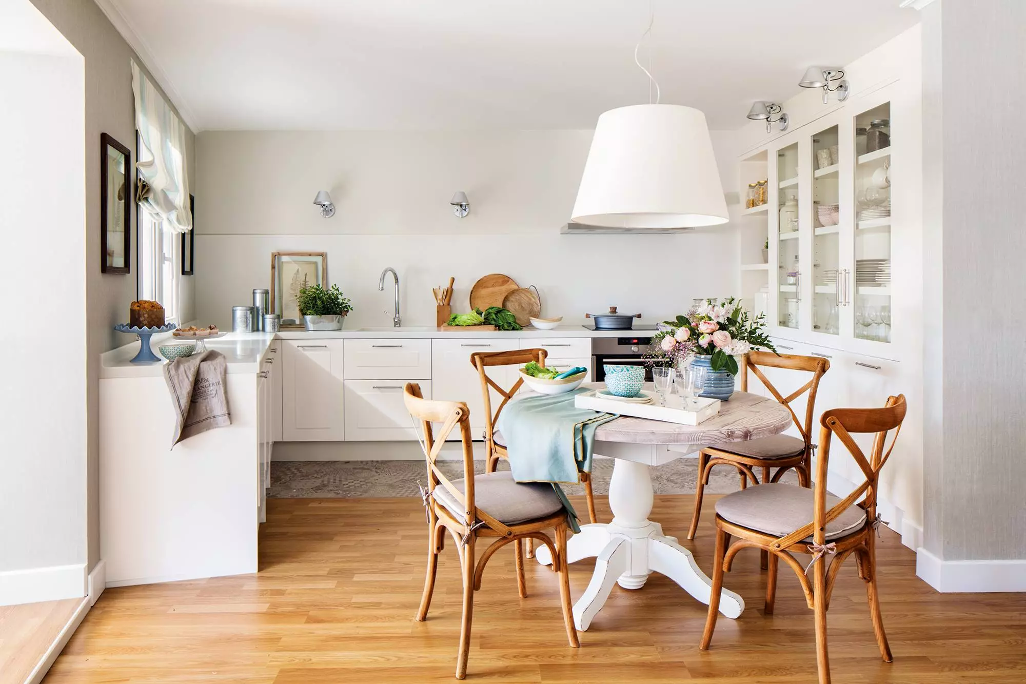 Cuisine qui intègre salle à manger avec table ronde en bois décapé