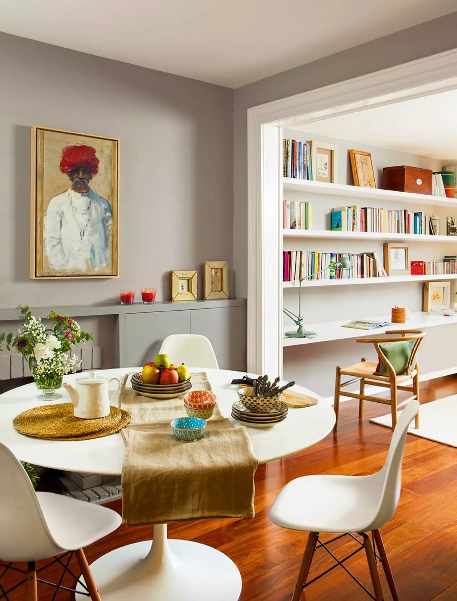 Salle à manger avec table design blanche ronde et tableau