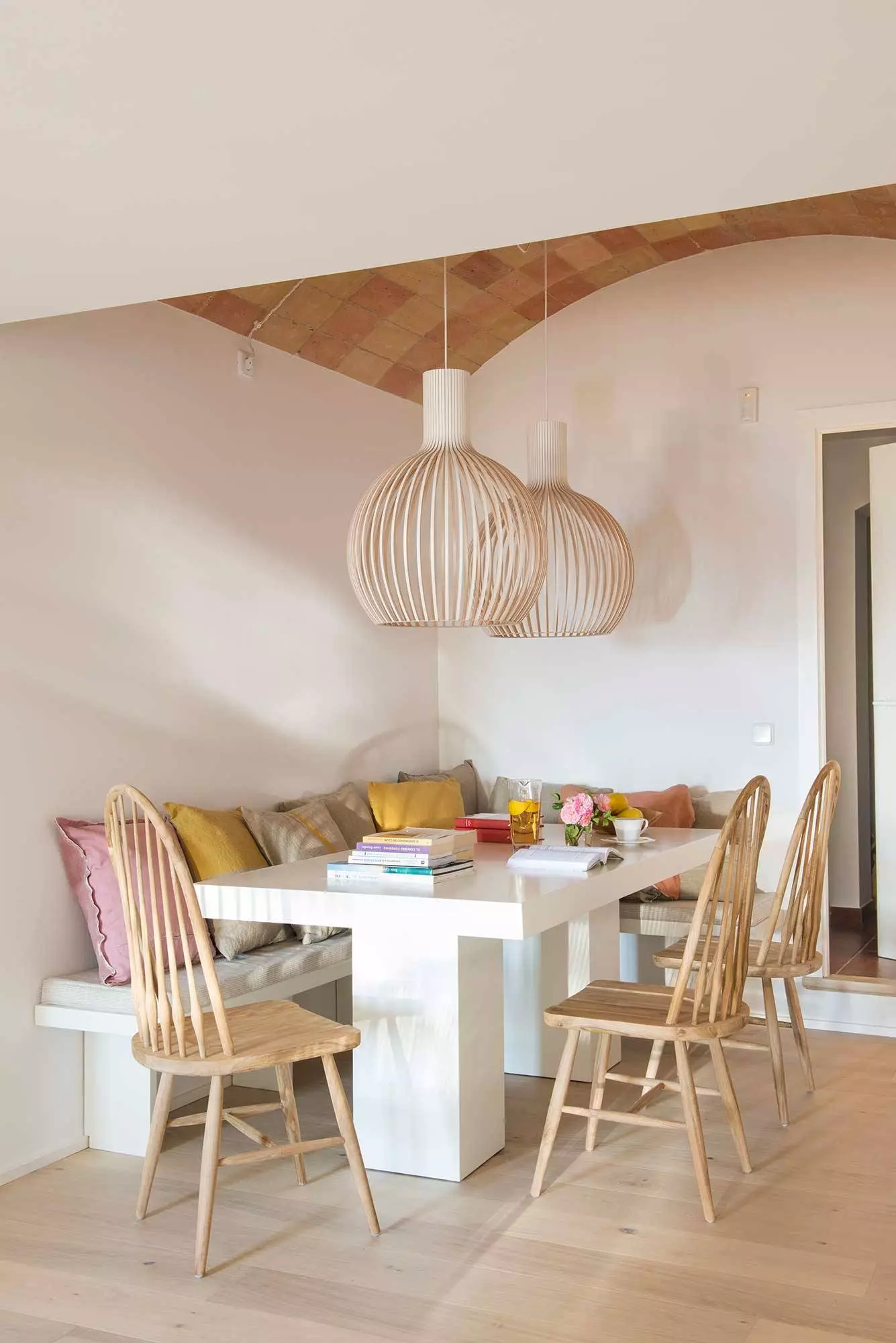 Salle à manger avec table blanche et plafond voûté