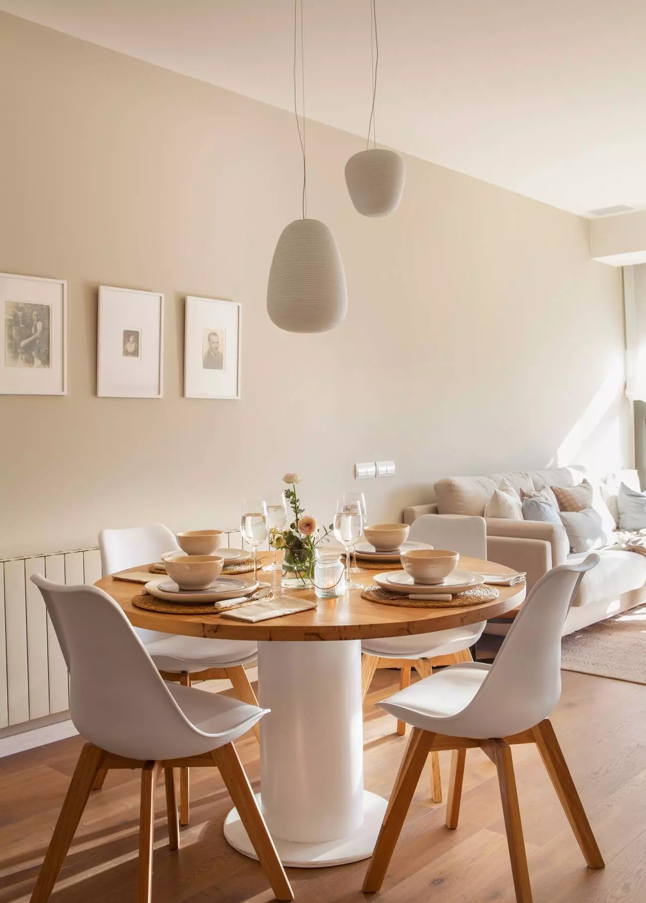 Sala de jantar com mesa redonda com tampo de madeira e pé central metálico