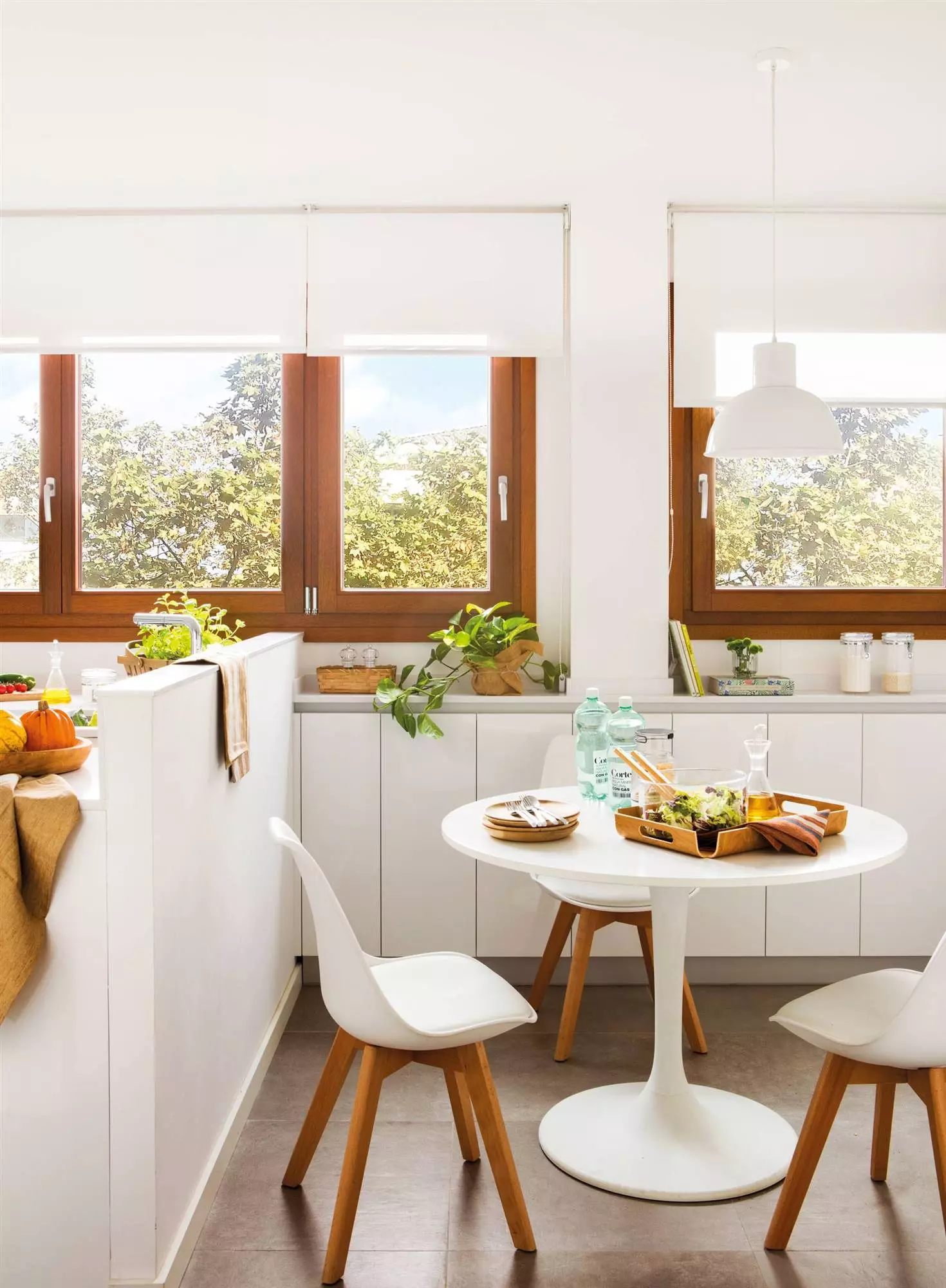 Sala de jantar ao lado da cozinha com uma pequena mesa redonda branca