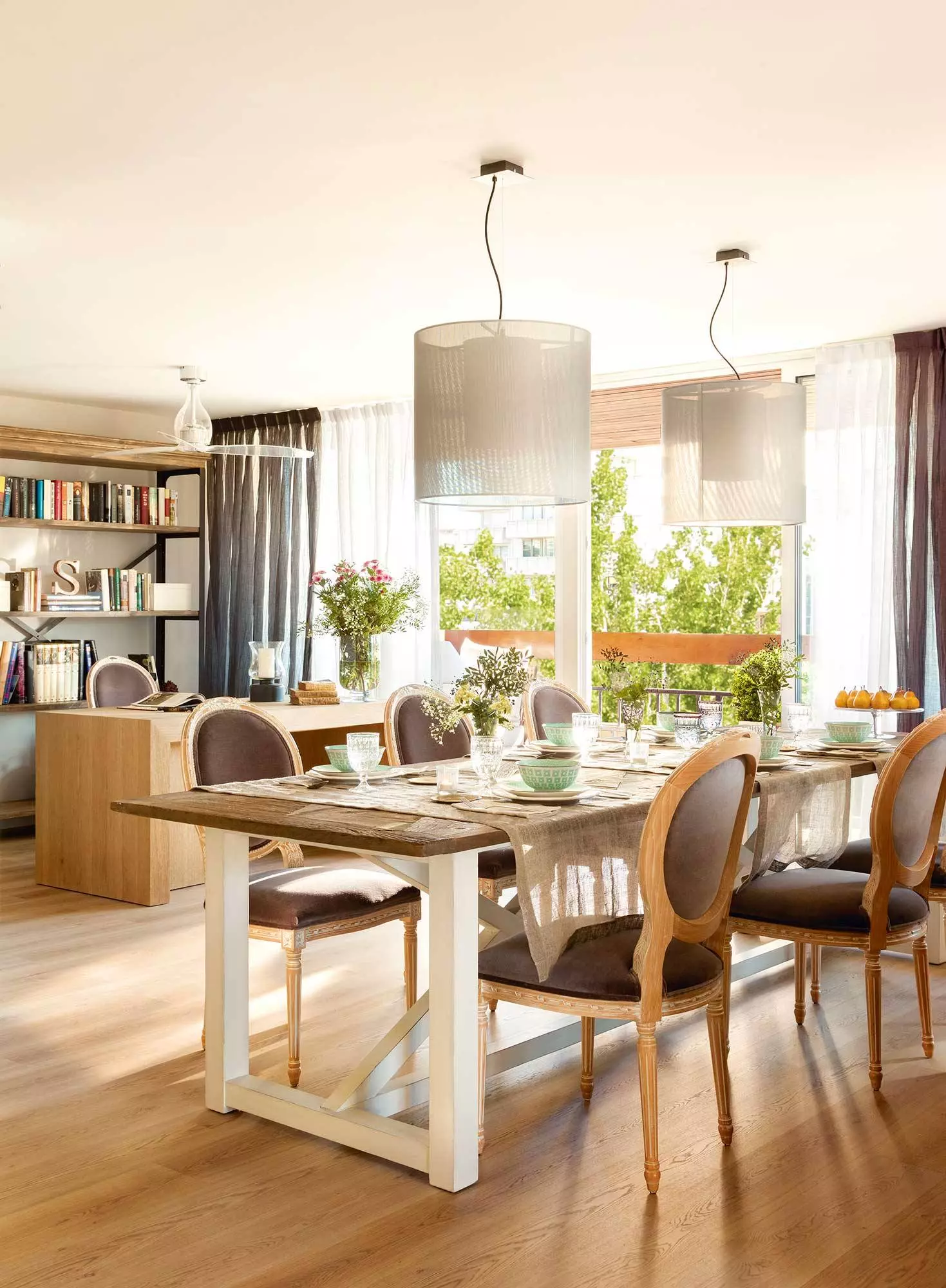 Comedor con mesa rectangular e zona de estudo con estantería