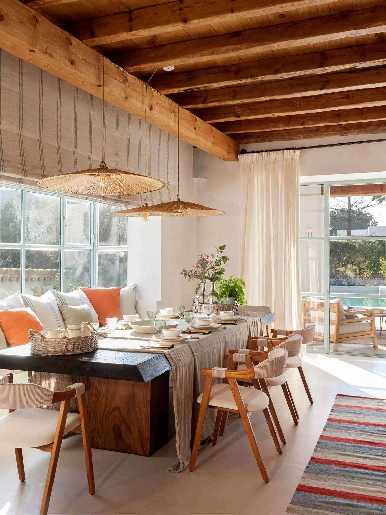 Salle à manger avec grande table et fenêtre sur le jardin