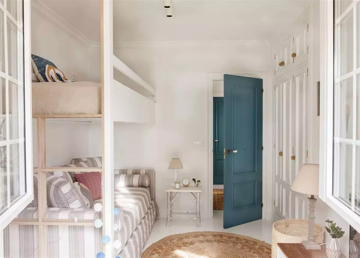 Kinderslaapkamer met stapelbed en deur in blauw