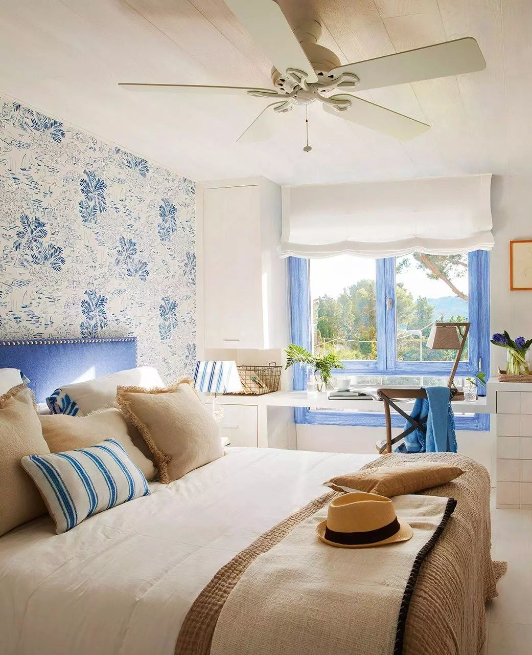 Bedroom with headboard in blue and white wallpaper